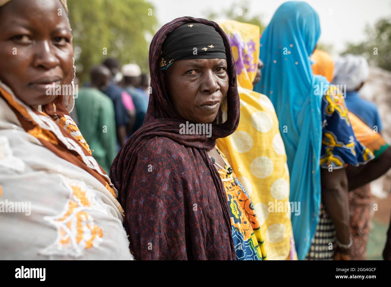 Women line up to receive food assistance at a IDP camp distribution ...