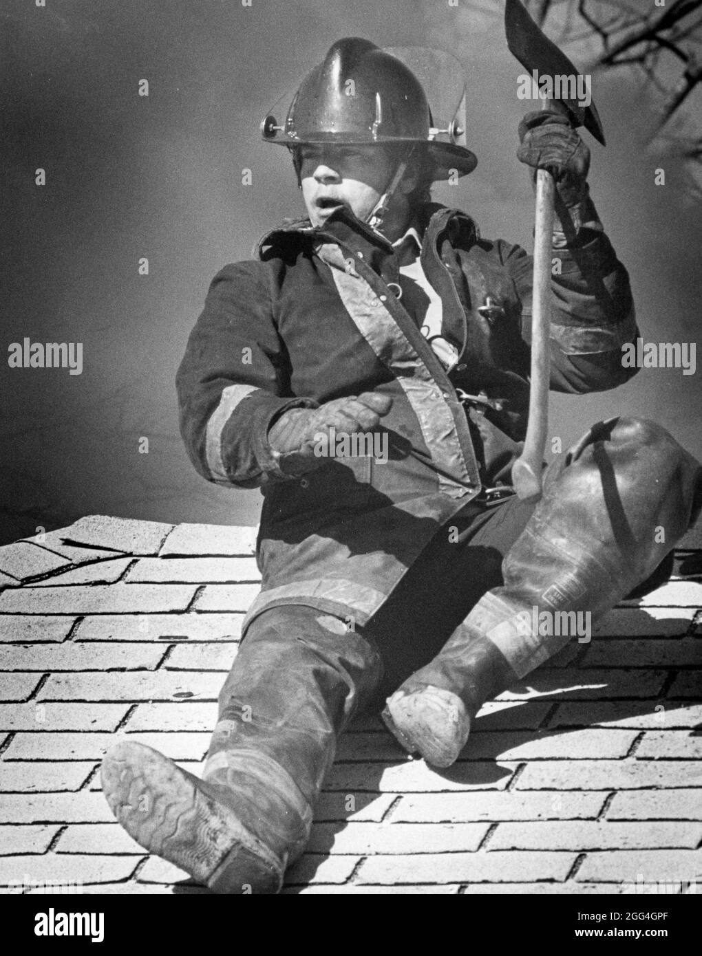 Austin Texas USA, 1983: Fireman on roof holding fire axe calls for more ...