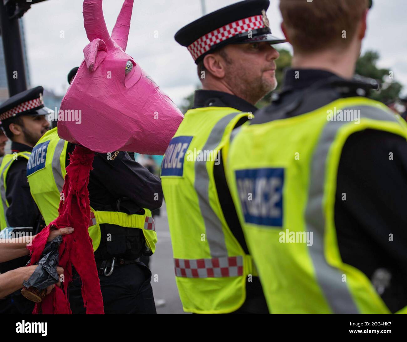 London, UK. 28th Aug, 2021. An activist adorned in a pink cow headpiece ...