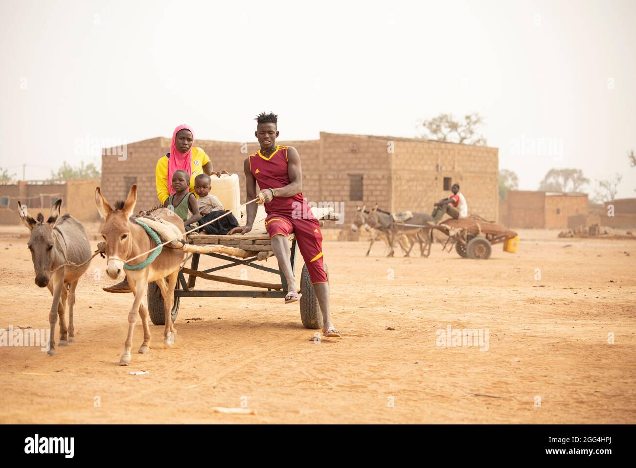 Youth use a donkey cart to fetch water in their rural village outside ...