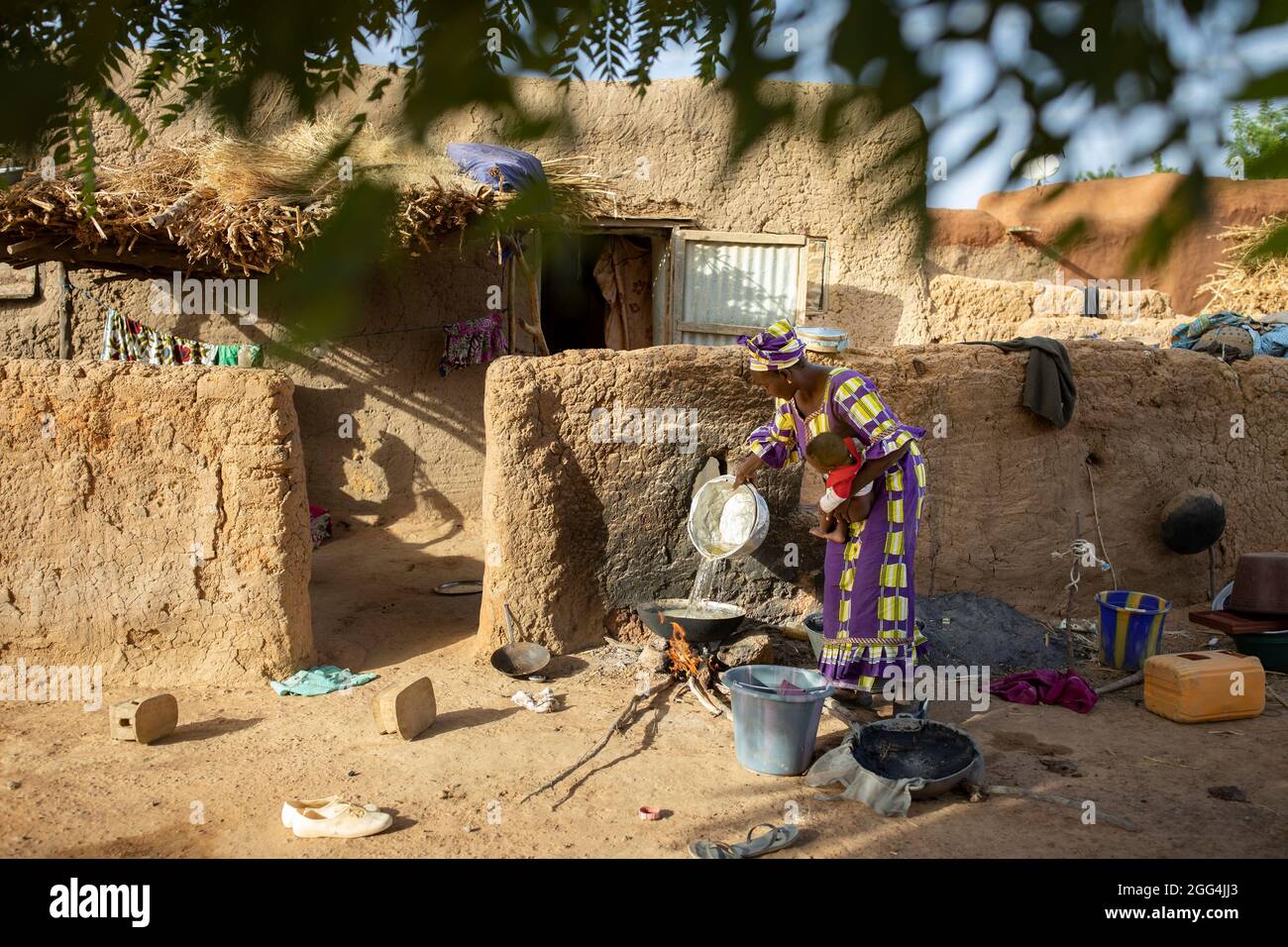 An African woman cooks over an open fire outside her village home in ...