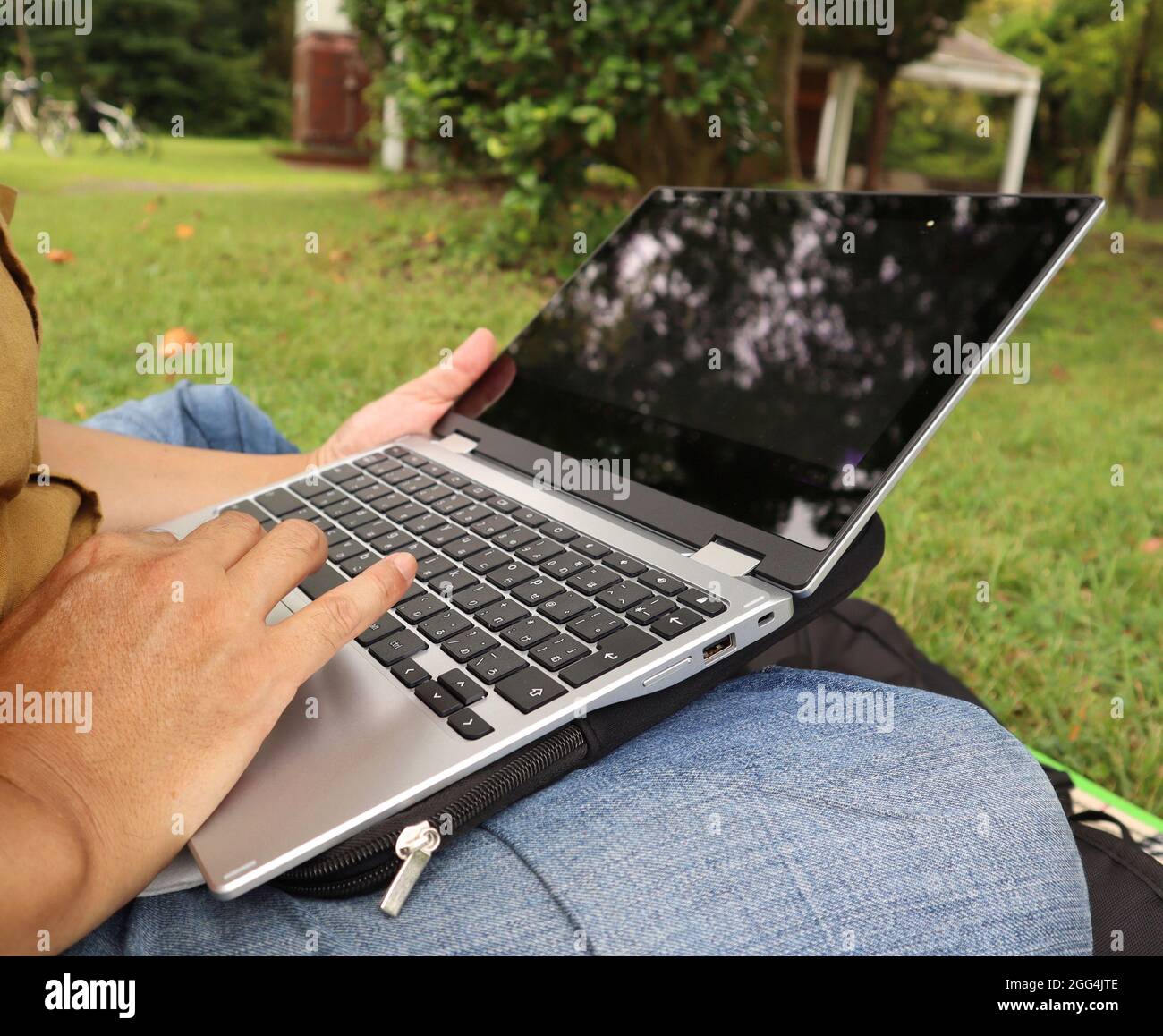 Man sitting by tree using laptop hi-res stock photography and images ...