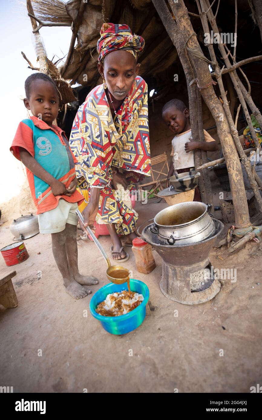 A woman serves her children breakfast porridge in from their home in ...