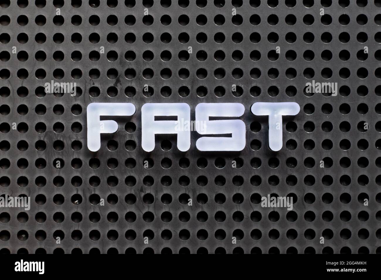 White color letter in word fast on black pegboard background Stock ...