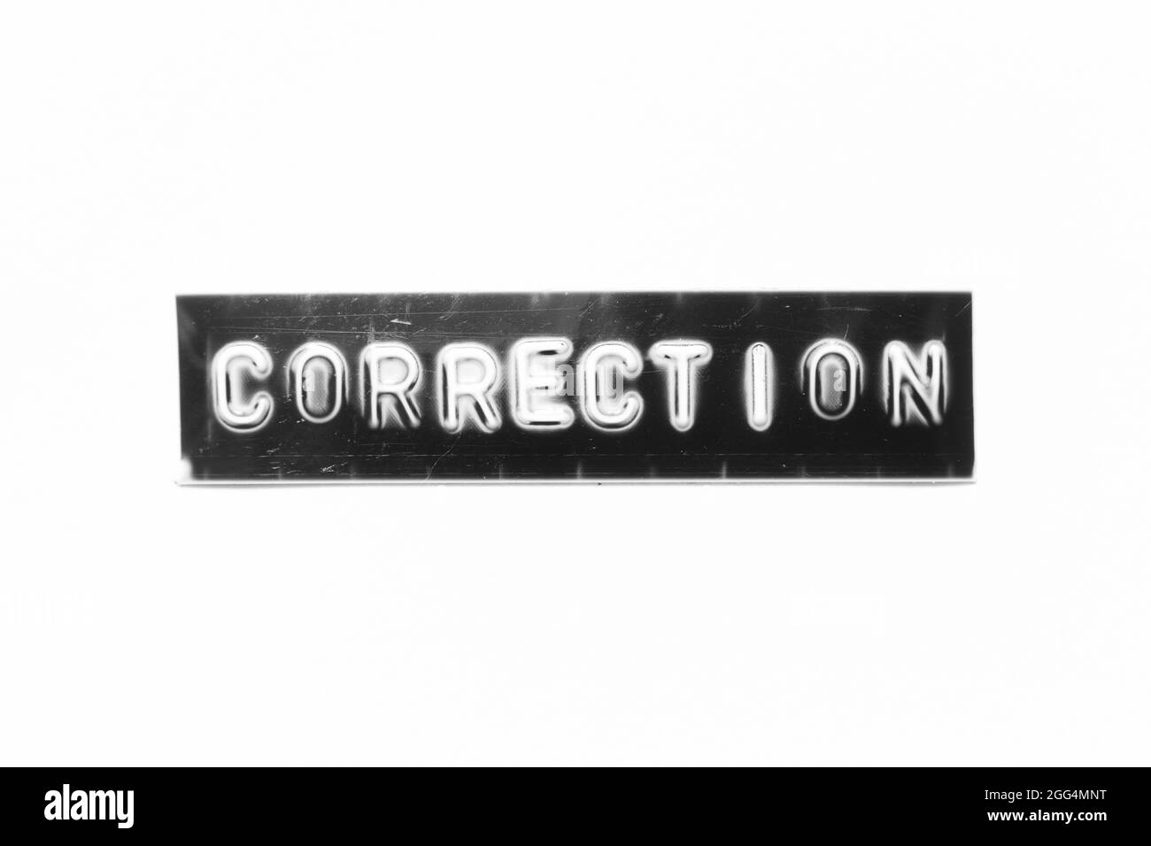 Embossed letter with word correction in black banner on white paper ...