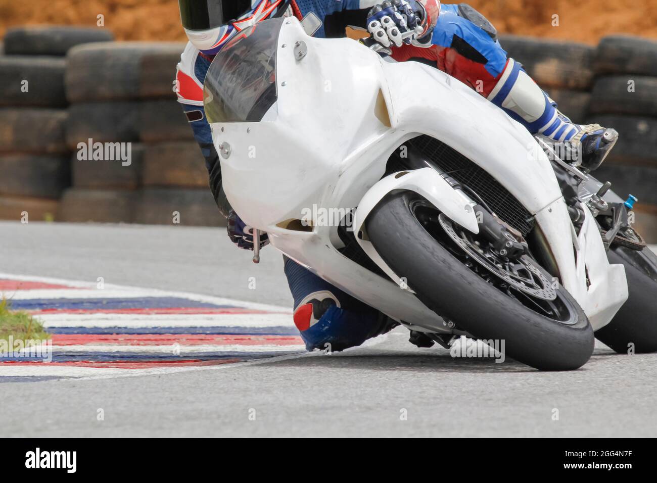 Racing bike rider leaning into a fast corner on track Stock Photo - Alamy