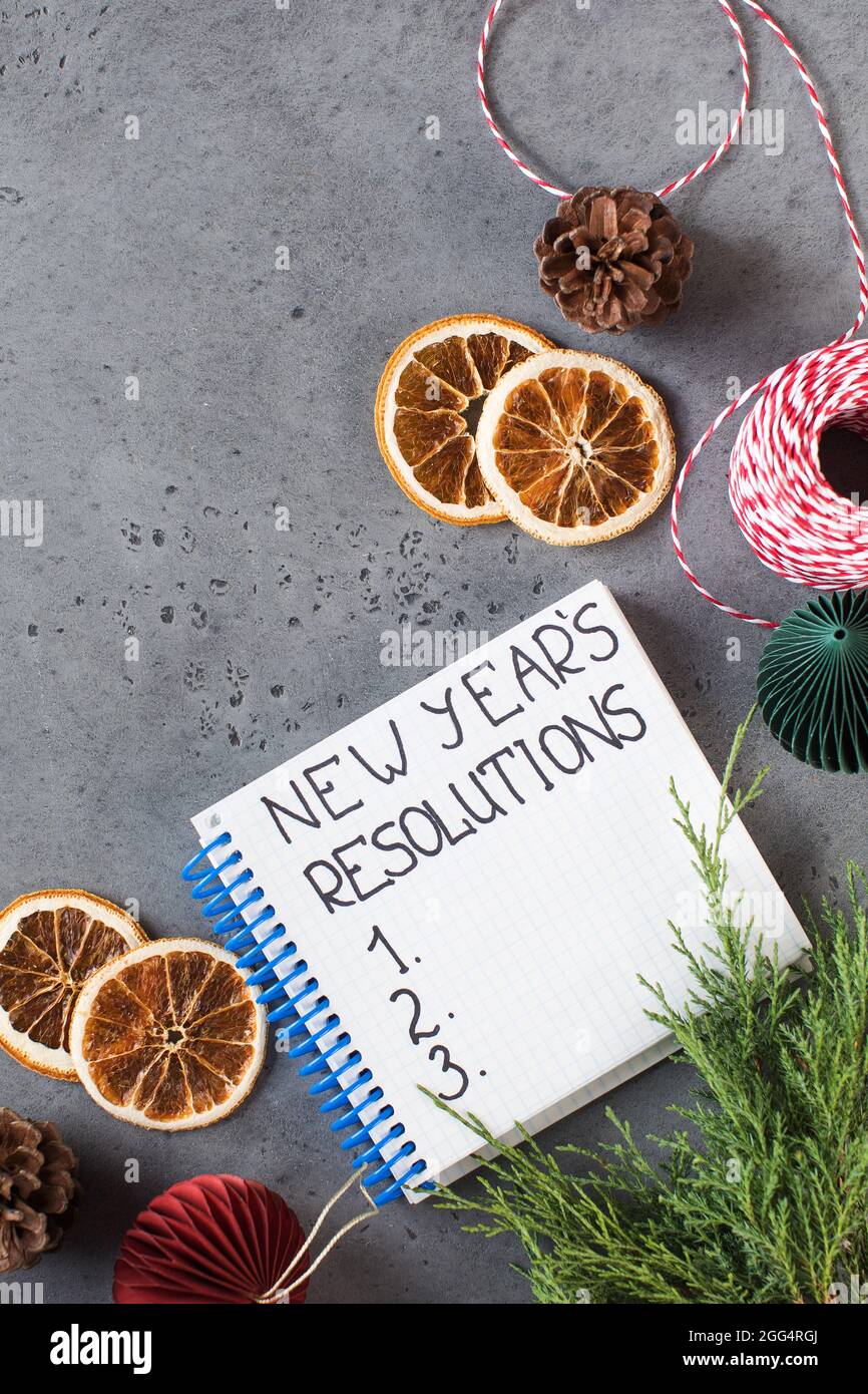 The word New Year's resolution, written in a white notebook on a gray ...