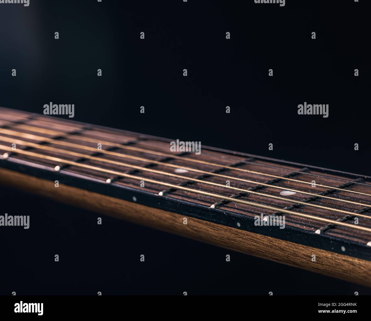 Part of an acoustic guitar, guitar fretboard on a black background ...