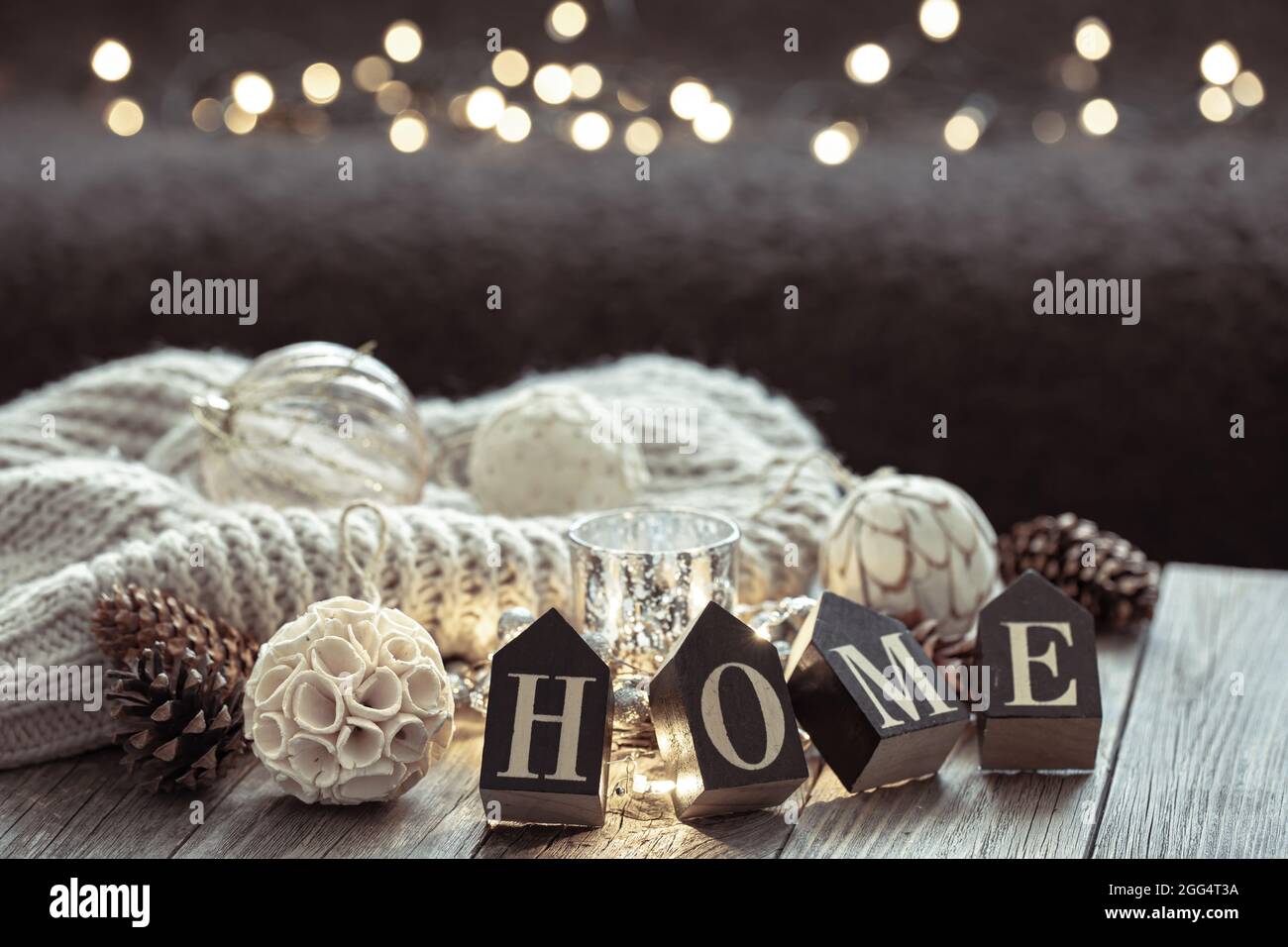 Close up of wooden letters make the word home, details of Christmas decor on blurred background ...