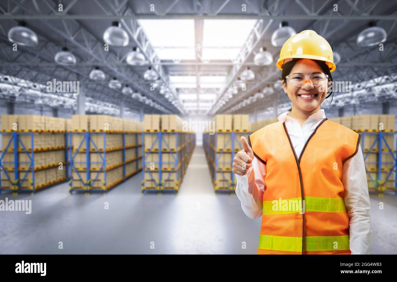 Asian worker in warehouse with stack of cardboard boxes Stock Photo - Alamy