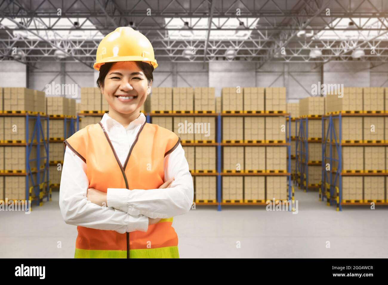 Asian worker in warehouse with stack of cardboard boxes Stock Photo - Alamy