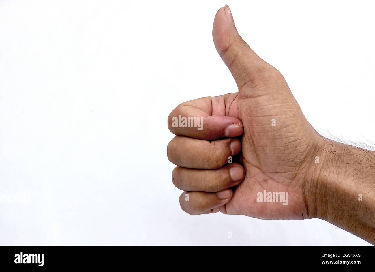 A closeup of male hand showing thumbs up sign against white background ...