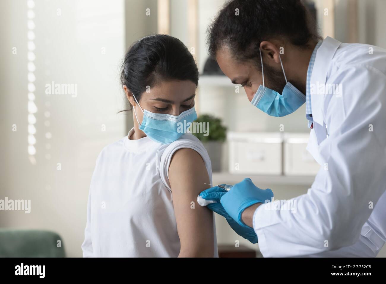 Happy young african doctor making injection to indian patient Stock ...