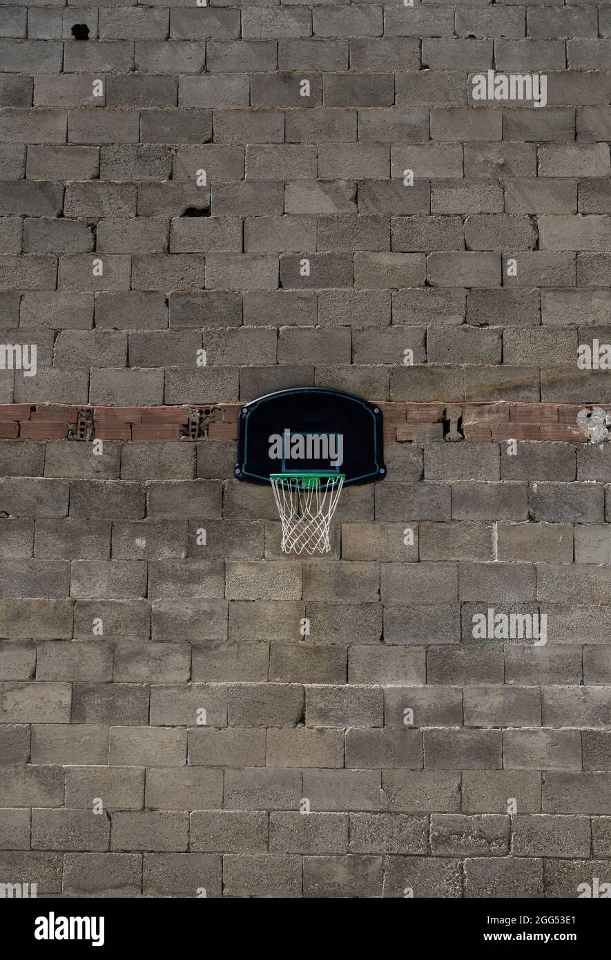 A vertical shot of a portable basketball hoop attached to a brick and ...