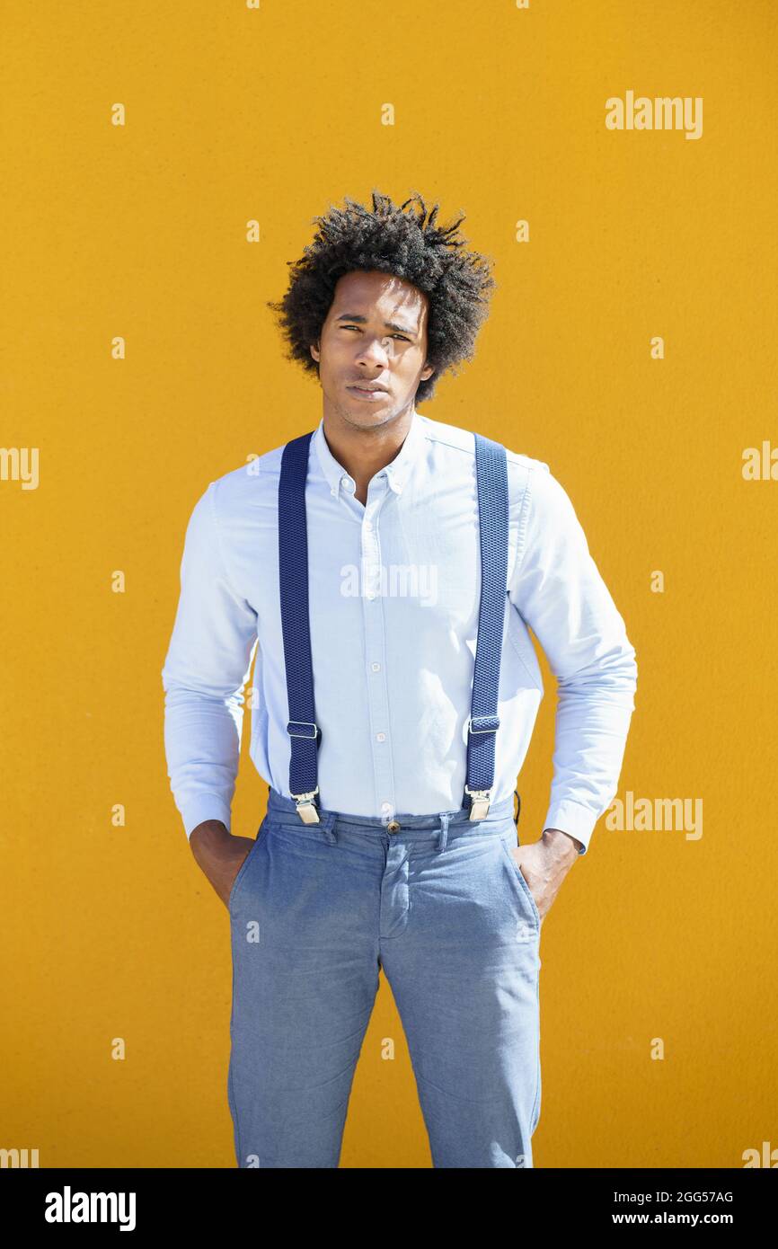 Black man with afro hair on yellow urban background wearing shirt and ...