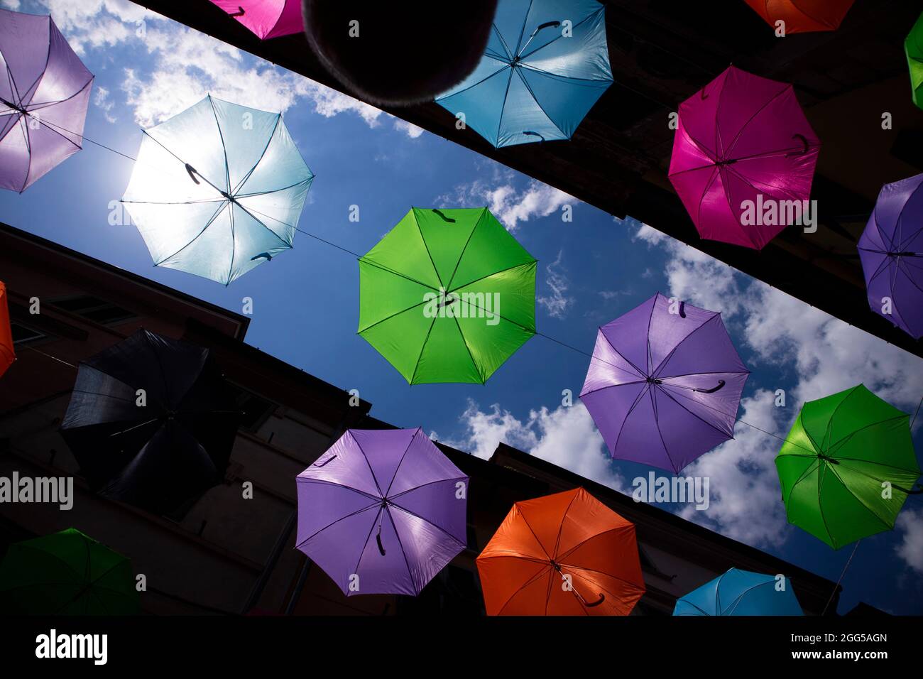 A series of umbrellas of different colors hung with a steel wire Stock ...