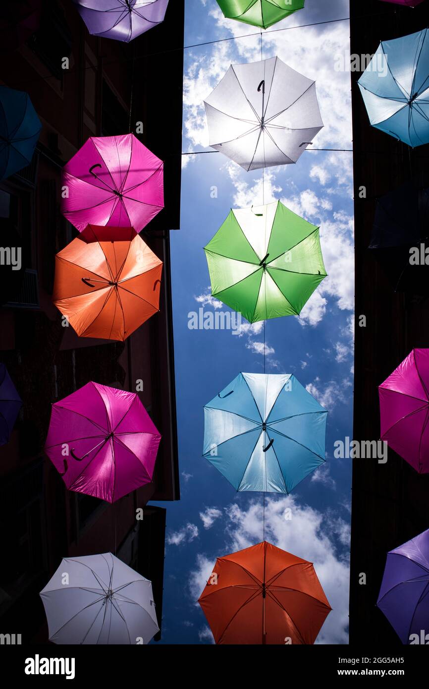 A series of umbrellas of different colors hung with a steel wire Stock ...