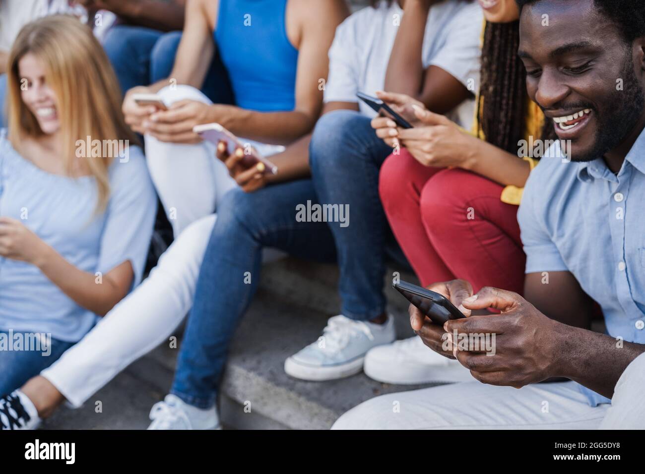 Young multiracial people using mobile phones outdoor in the city ...