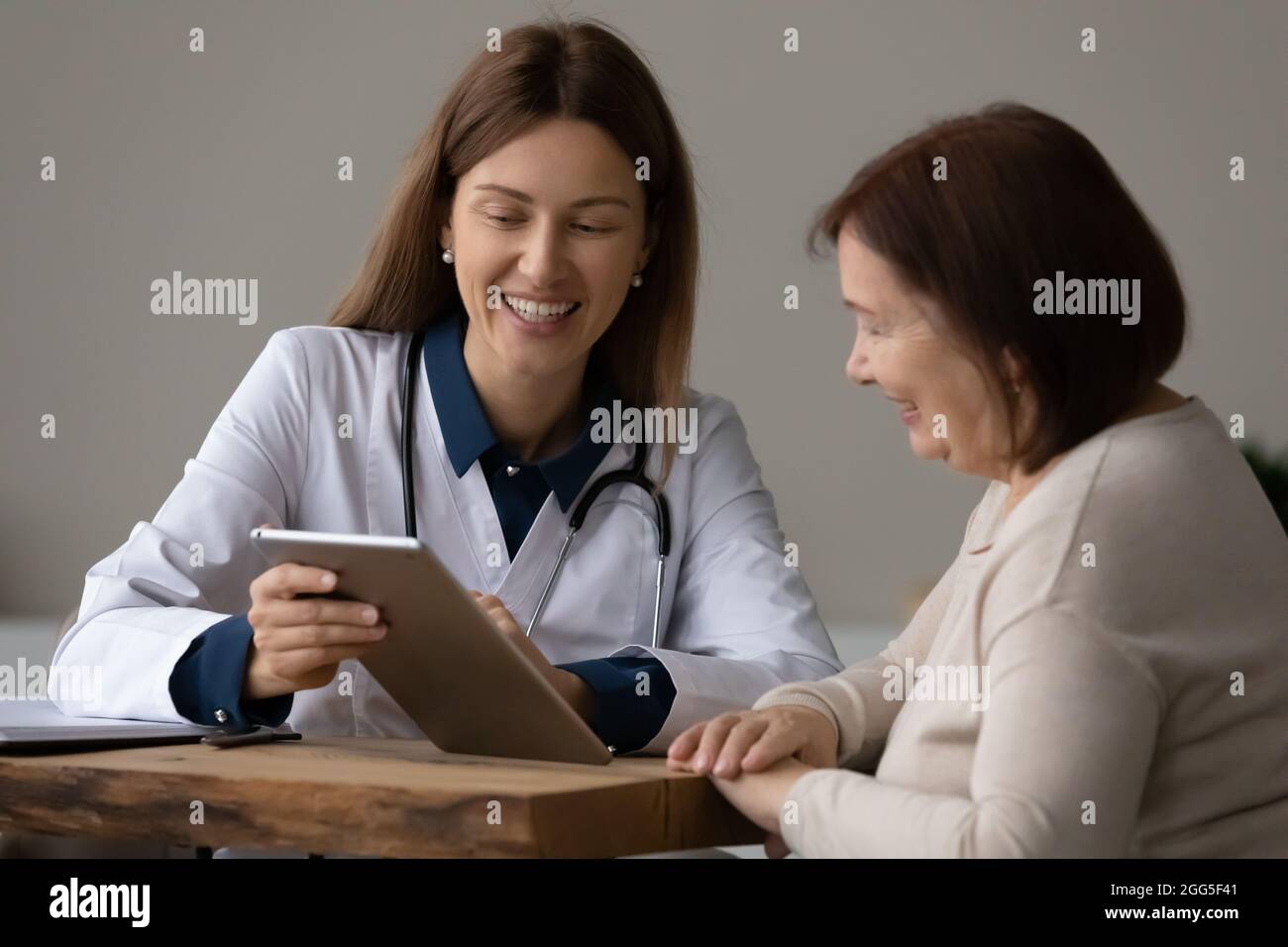 Older doctor on device hi-res stock photography and images - Alamy
