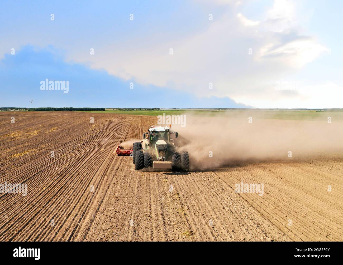 Agricultural tractor on cultivating field for sowing seeds. Farming and ...