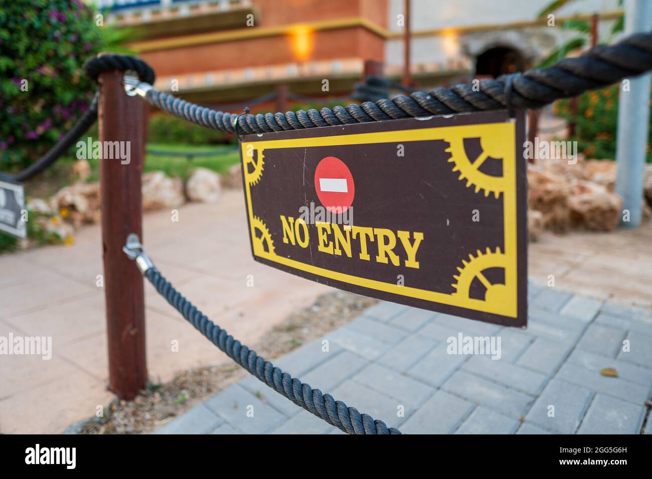 a closeup shot of no entry placard hanging on rope fences at daylight ...