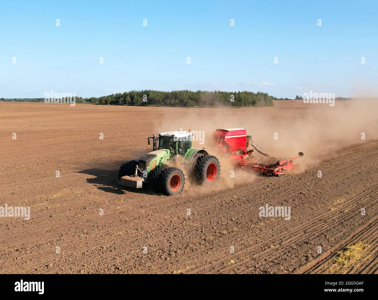 Agricultural tractor on cultivating field for sowing seeds. Farming and ...