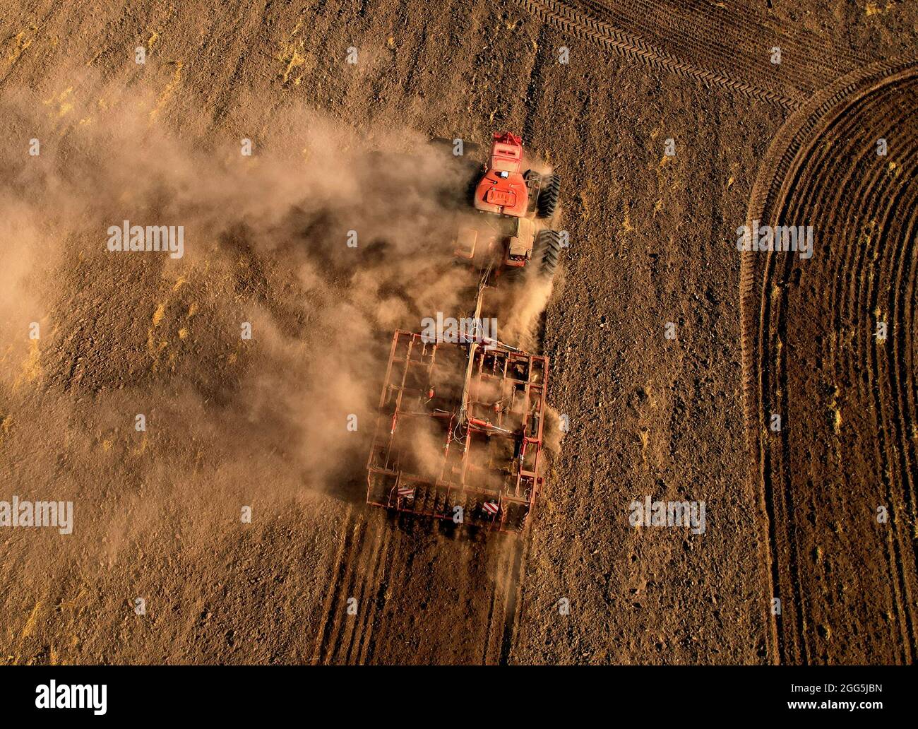 Soil Tillage in farmers country. Red Tractor on cultivating field work ...