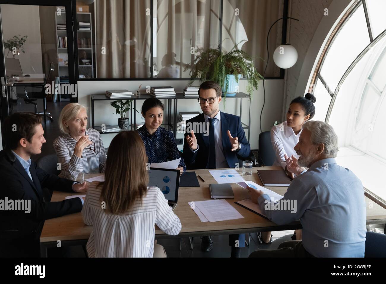 Diverse employees team listening to coworker at meeting in office Stock ...