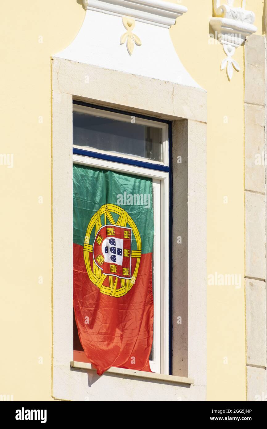 beautiful flag of portugal hanging on a window of a house in Lagos ...
