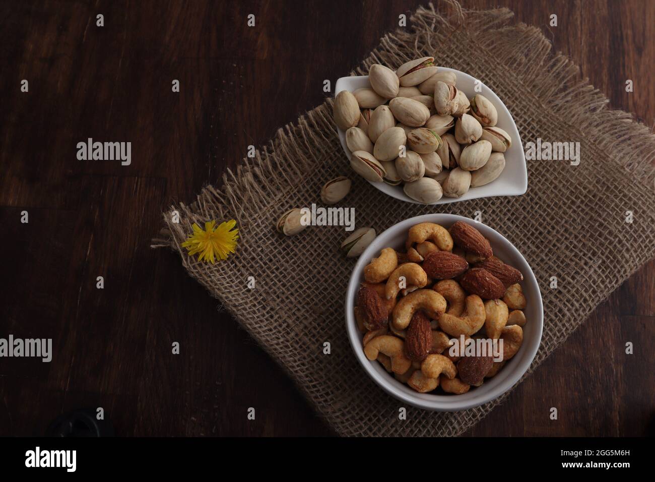Mix nuts in bowls on wooden table. assorted nuts, pistachios, almonds ...