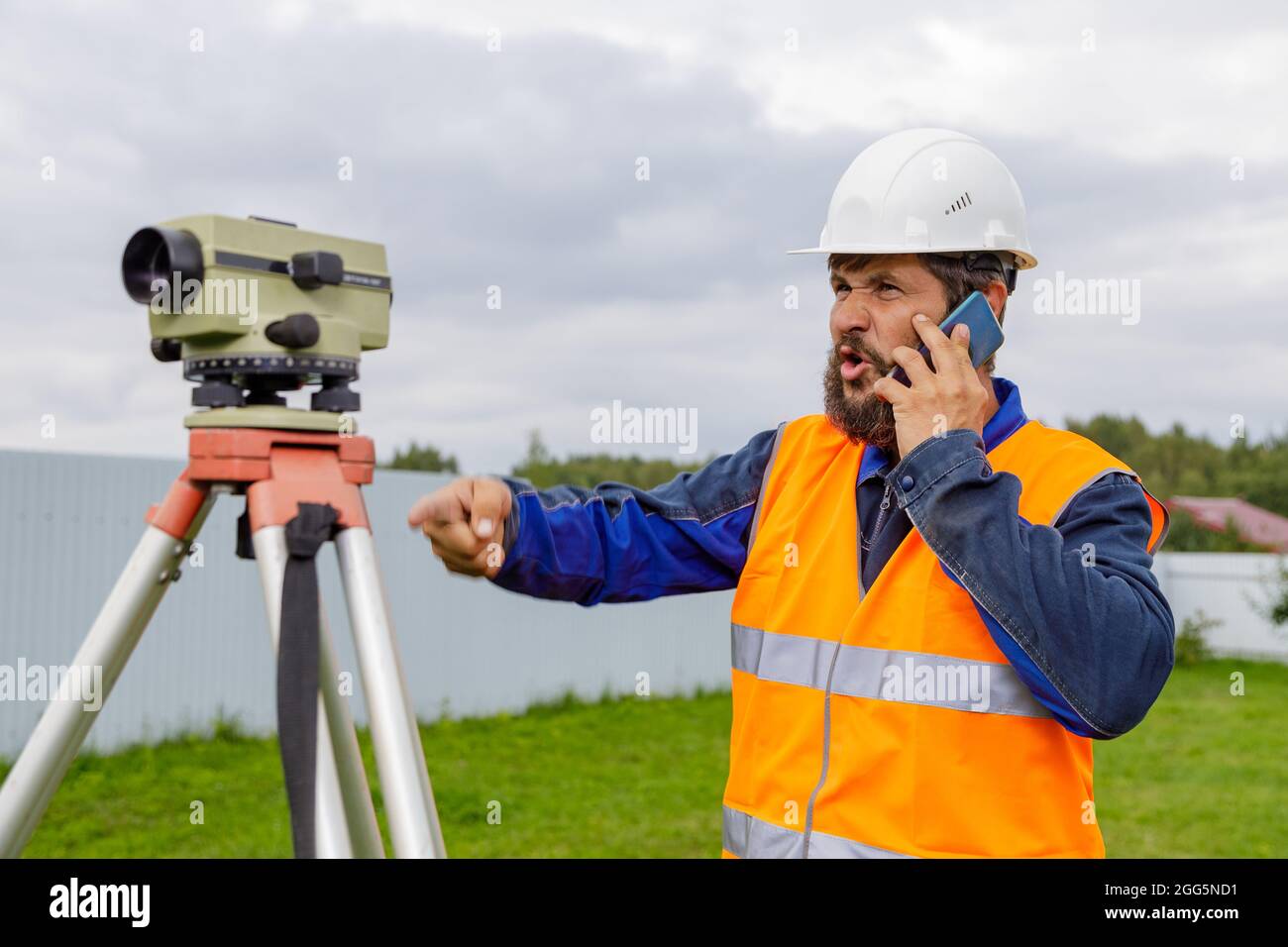 A disgruntled civil engineer with an optical level gauge speaks on a ...
