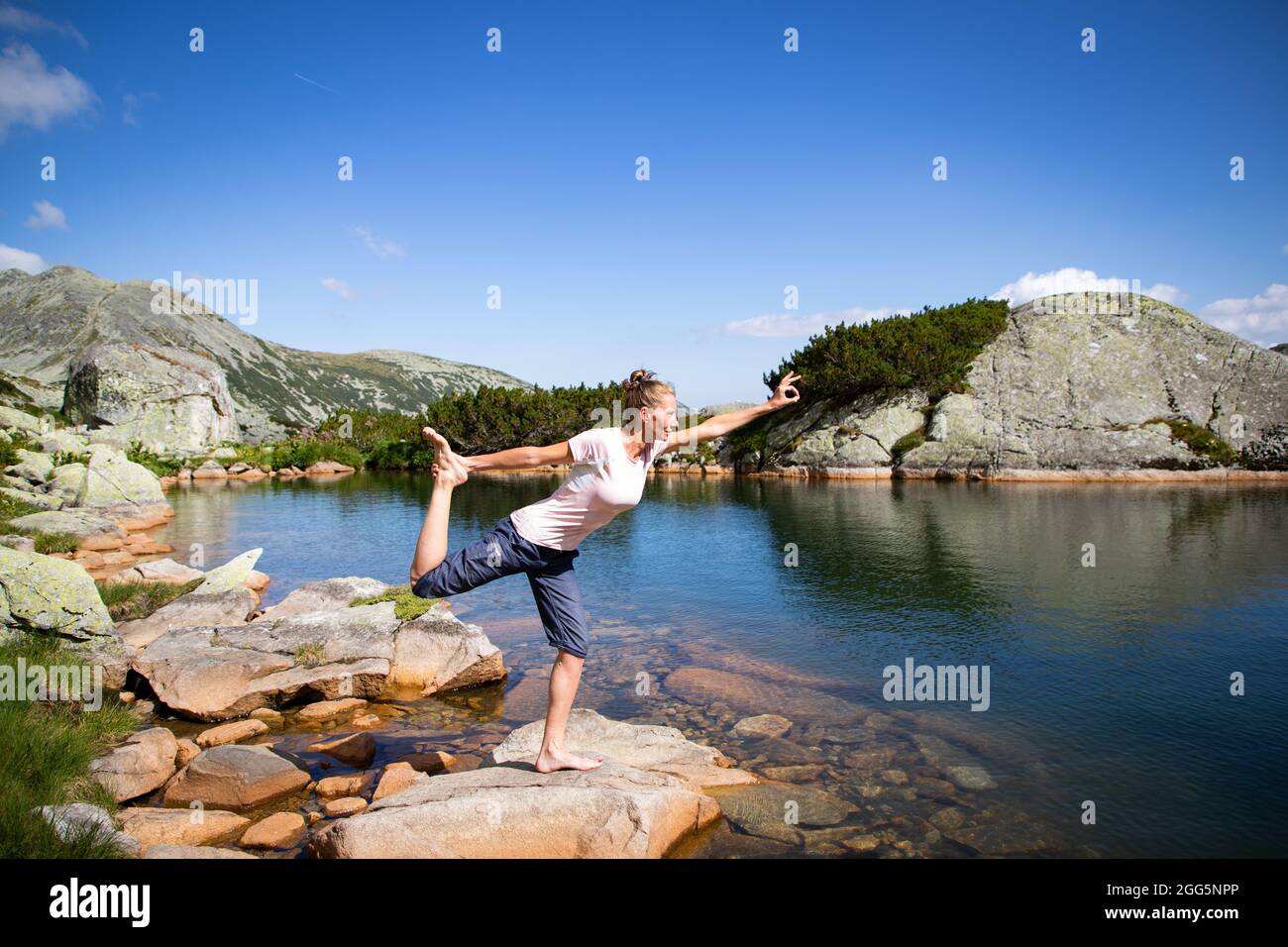 healthy young woman doing yoga in mountain landscape by lake Stock ...