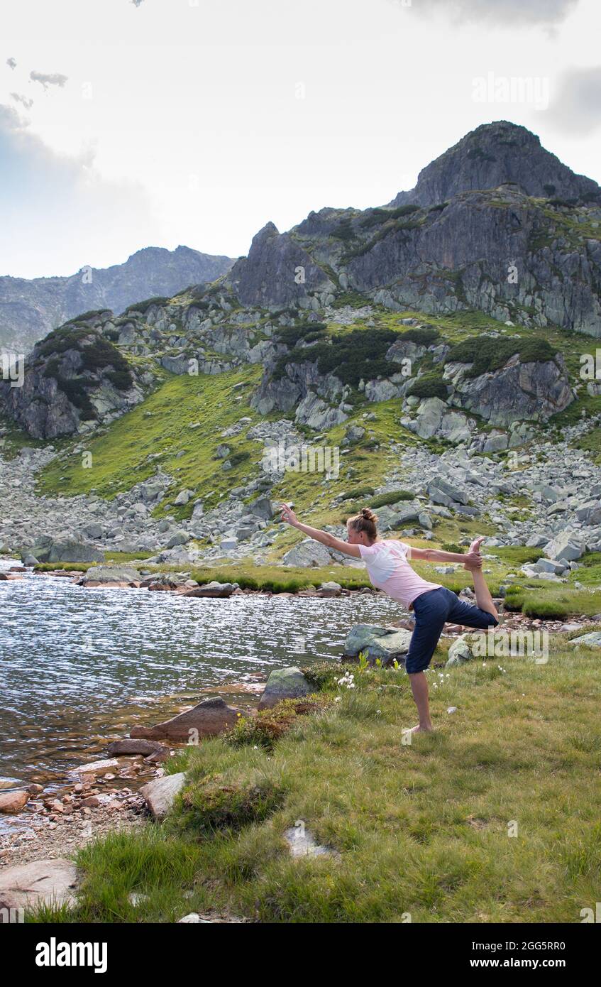 healthy young woman doing yoga in mountain landscape by lake Stock ...