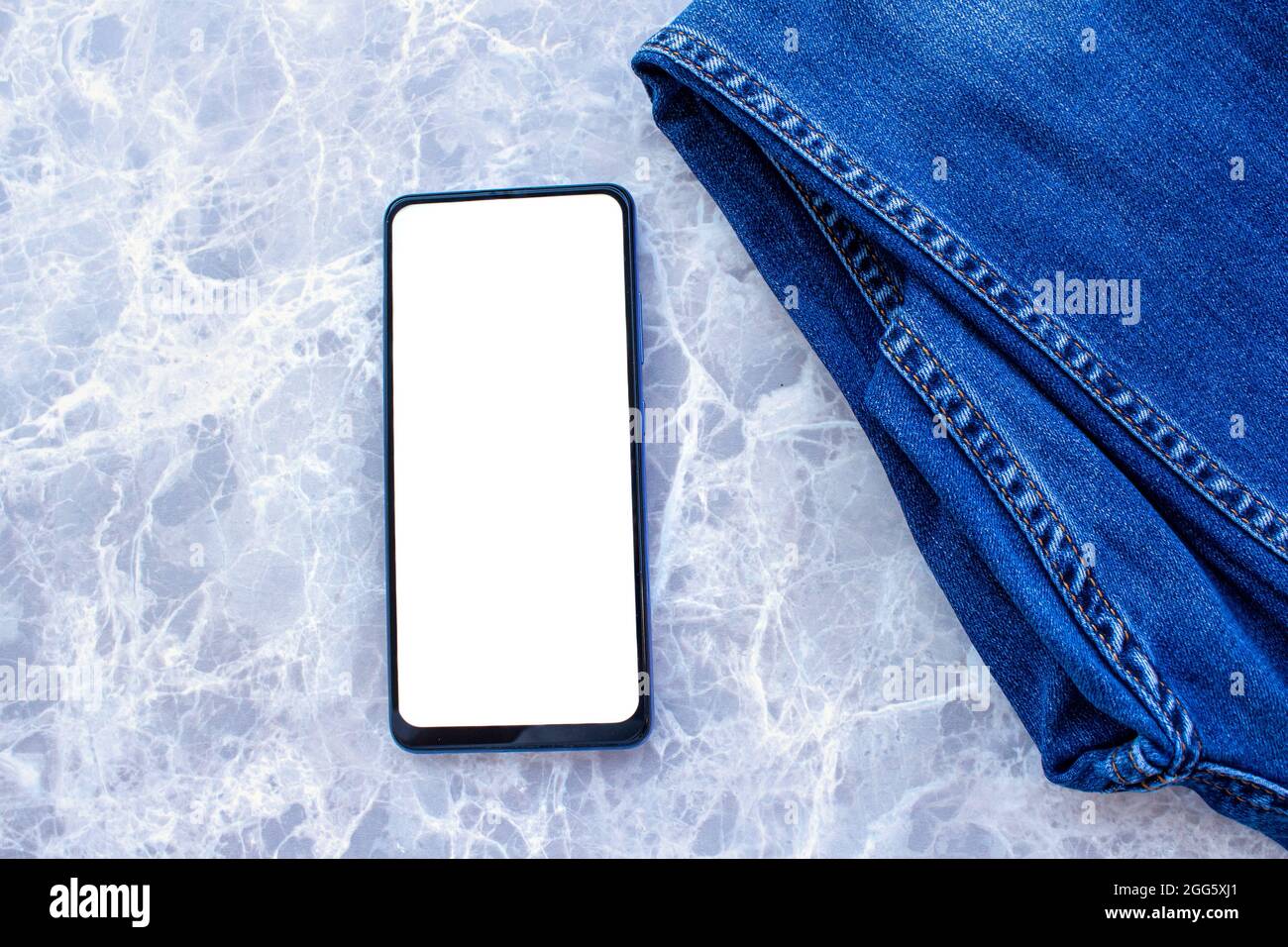White desktop screen mobile phone on marble background with blue denim ...