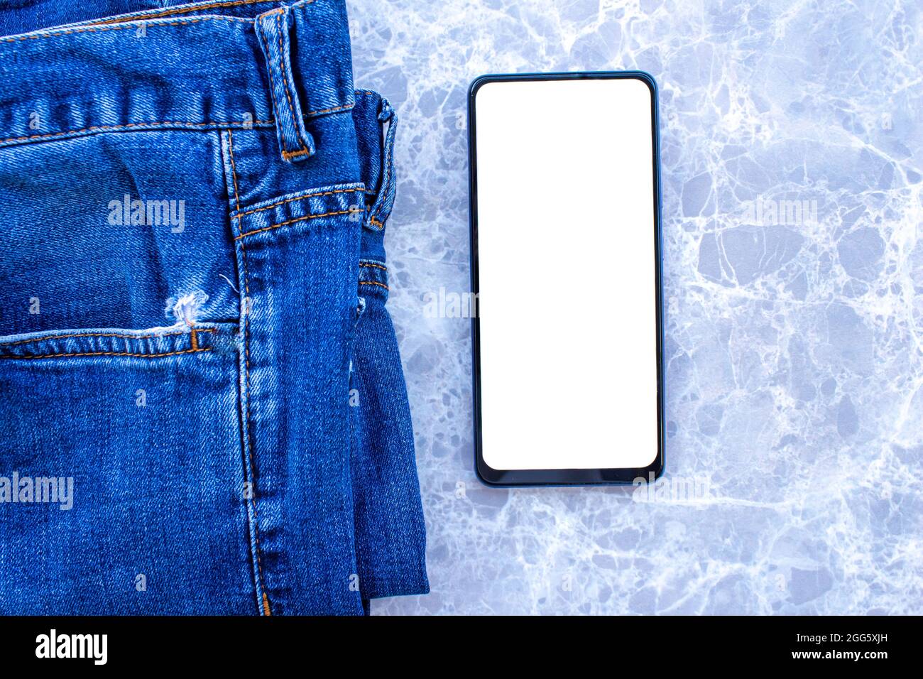 White desktop screen mobile phone on marble background with blue denim ...
