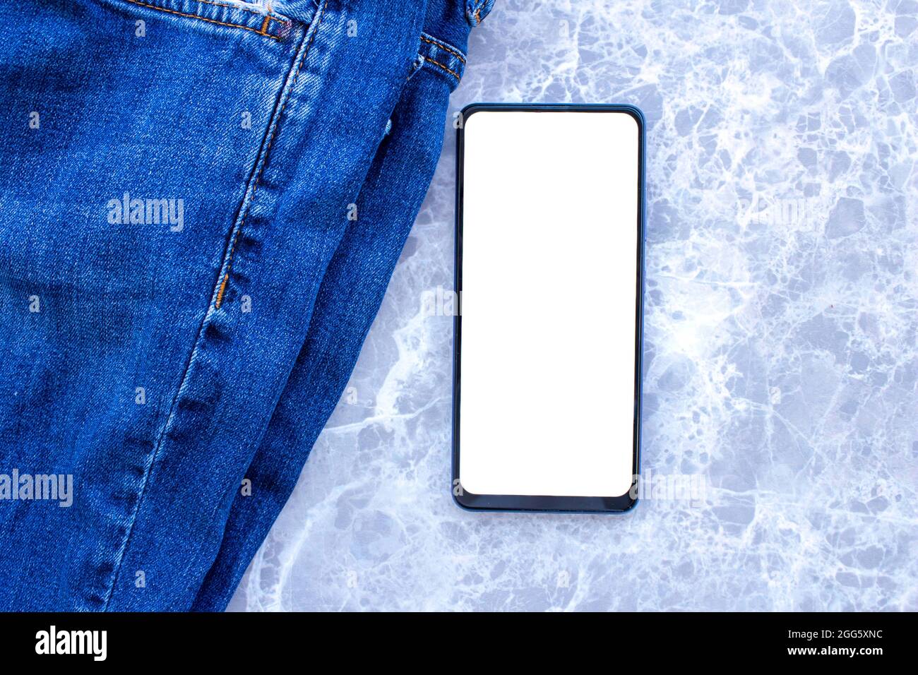 White desktop screen mobile phone on marble background with blue denim ...