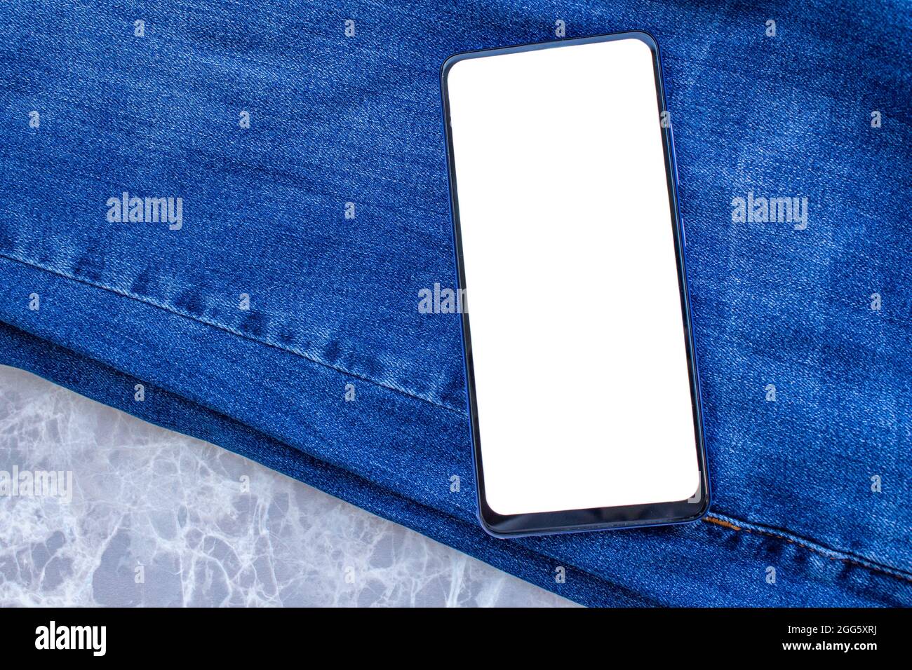 White desktop screen mobile phone on marble background with blue denim ...