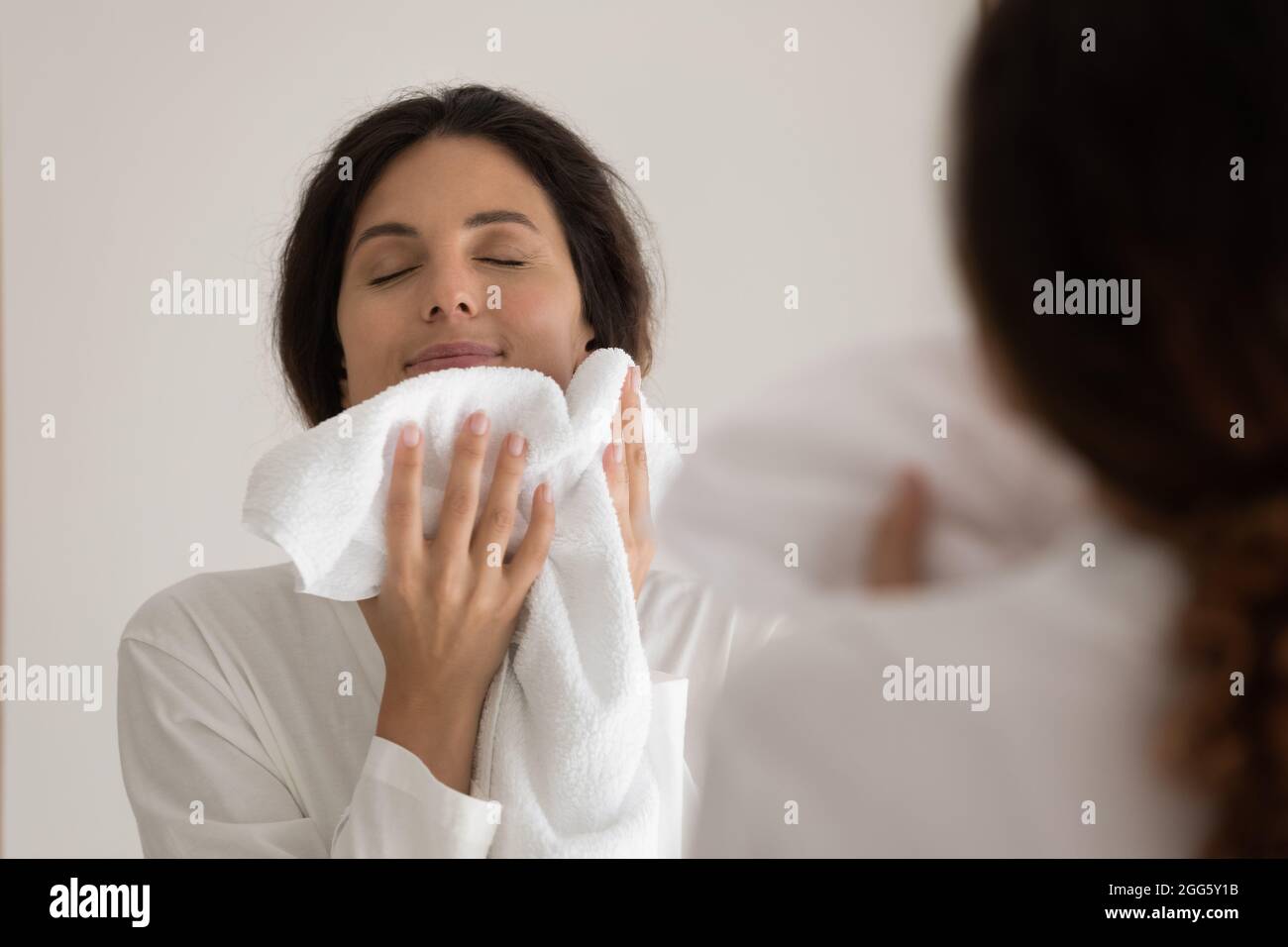 Happy young woman wiping face with towel Stock Photo - Alamy