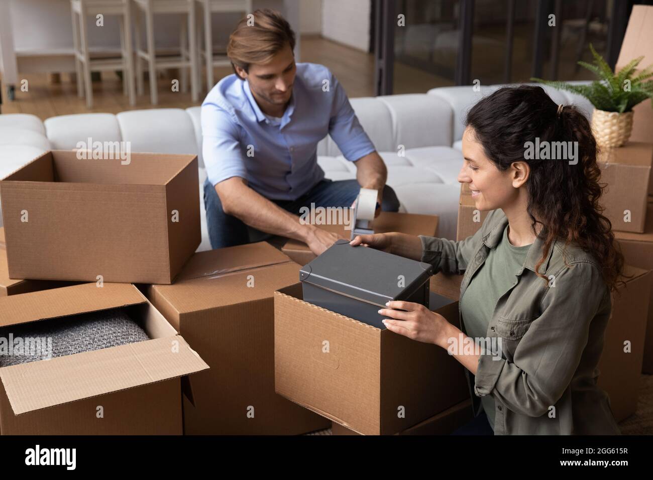 Happy young family couple unpacking carton boxes Stock Photo - Alamy