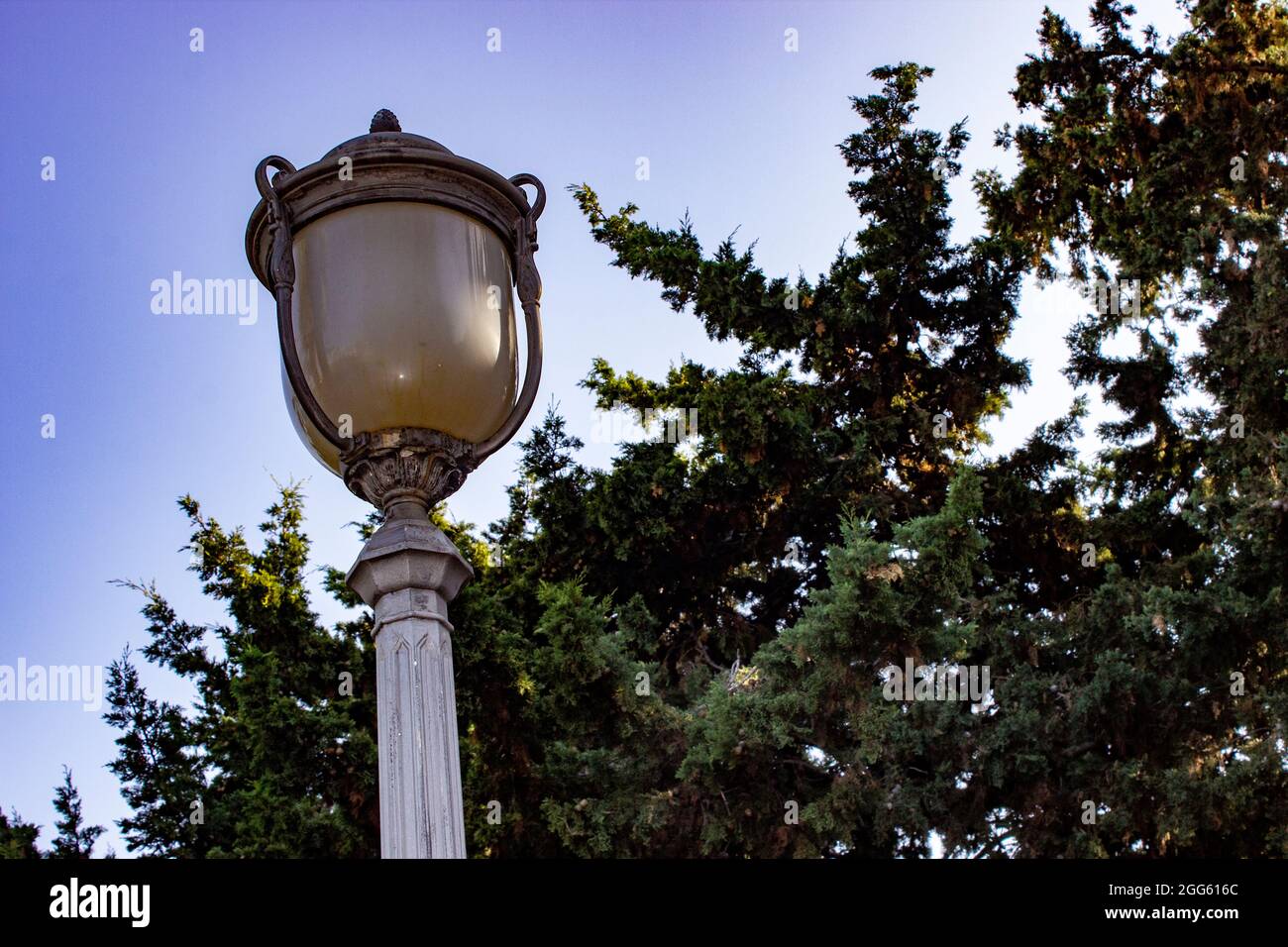Steel vintage lamp post in the park at the sunset Stock Photo - Alamy