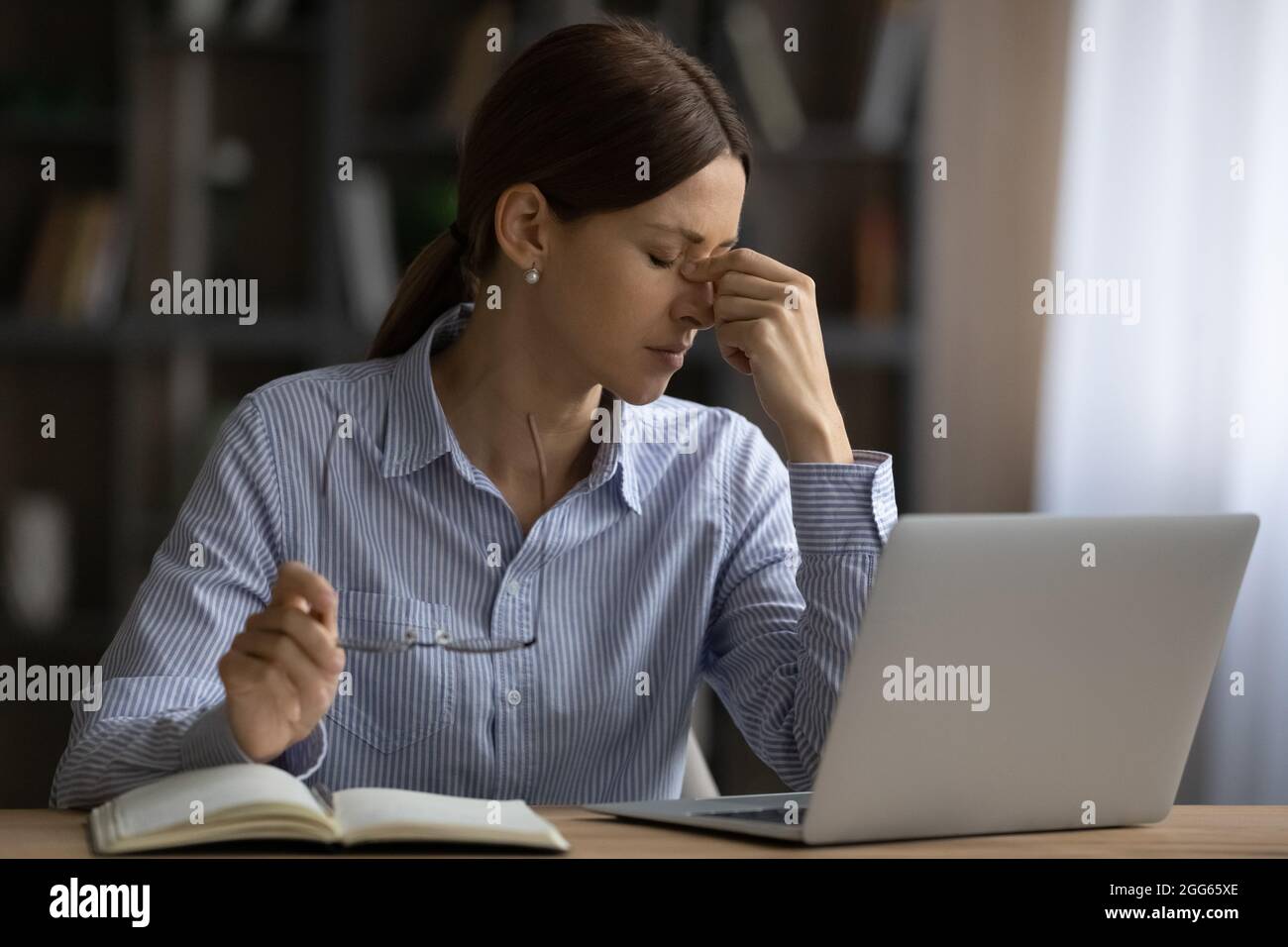 Exhausted young woman taking off glasses, feeling eye strain Stock ...