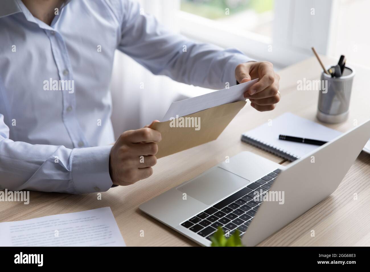 Hands of businessman opening envelope with white paper Stock Photo - Alamy