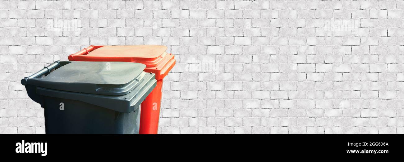 Panoramic banner of two trash bin on white brick background. Separate ...