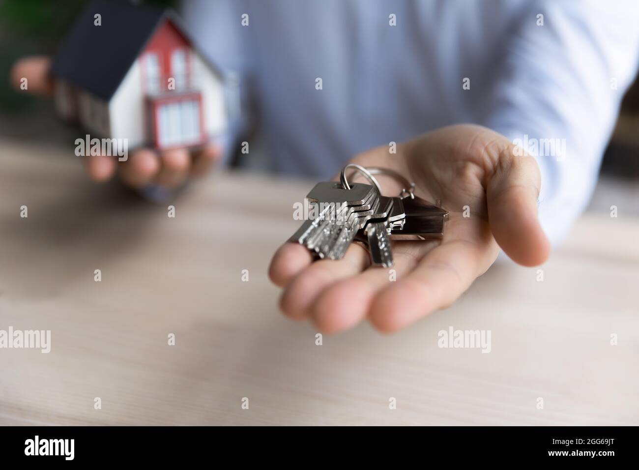 Hand of realtor giving key from new home Stock Photo - Alamy