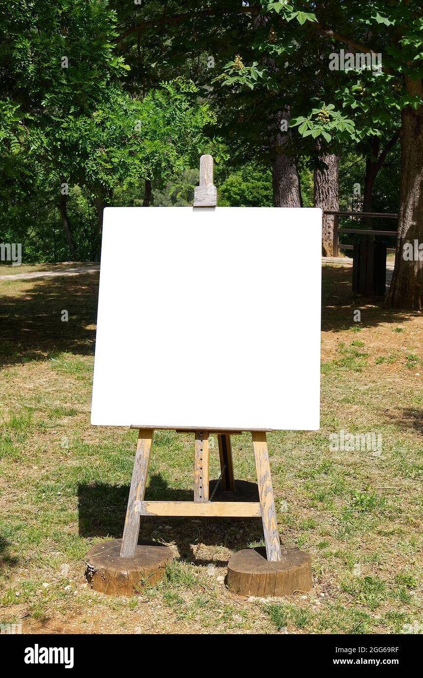Easel with a blank white sheet of paper stands against the backdrop of ...