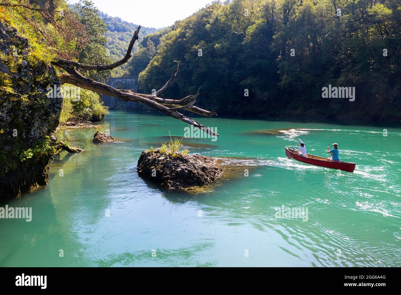Aerial view of mother and son rowing in a red canoe on Soca river under ...