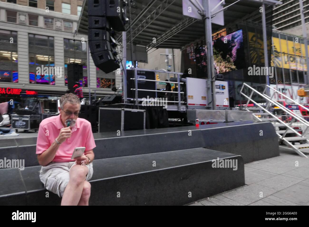 Seated Man with Pipe and Pink Shirt in Times Square Stock Photo - Alamy