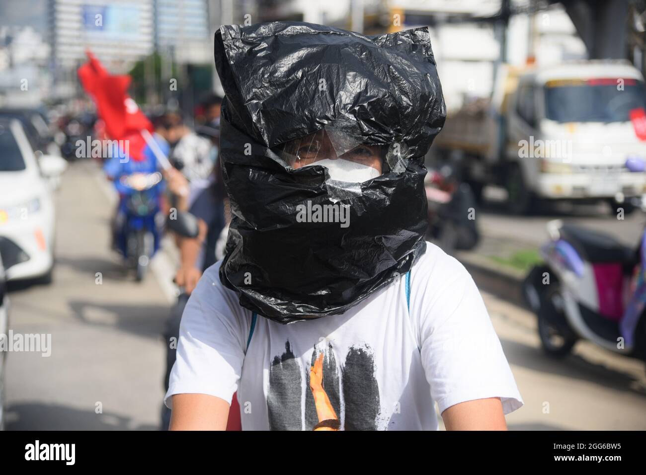 A protester wears a plastic bag on his head during a car mob rally ...