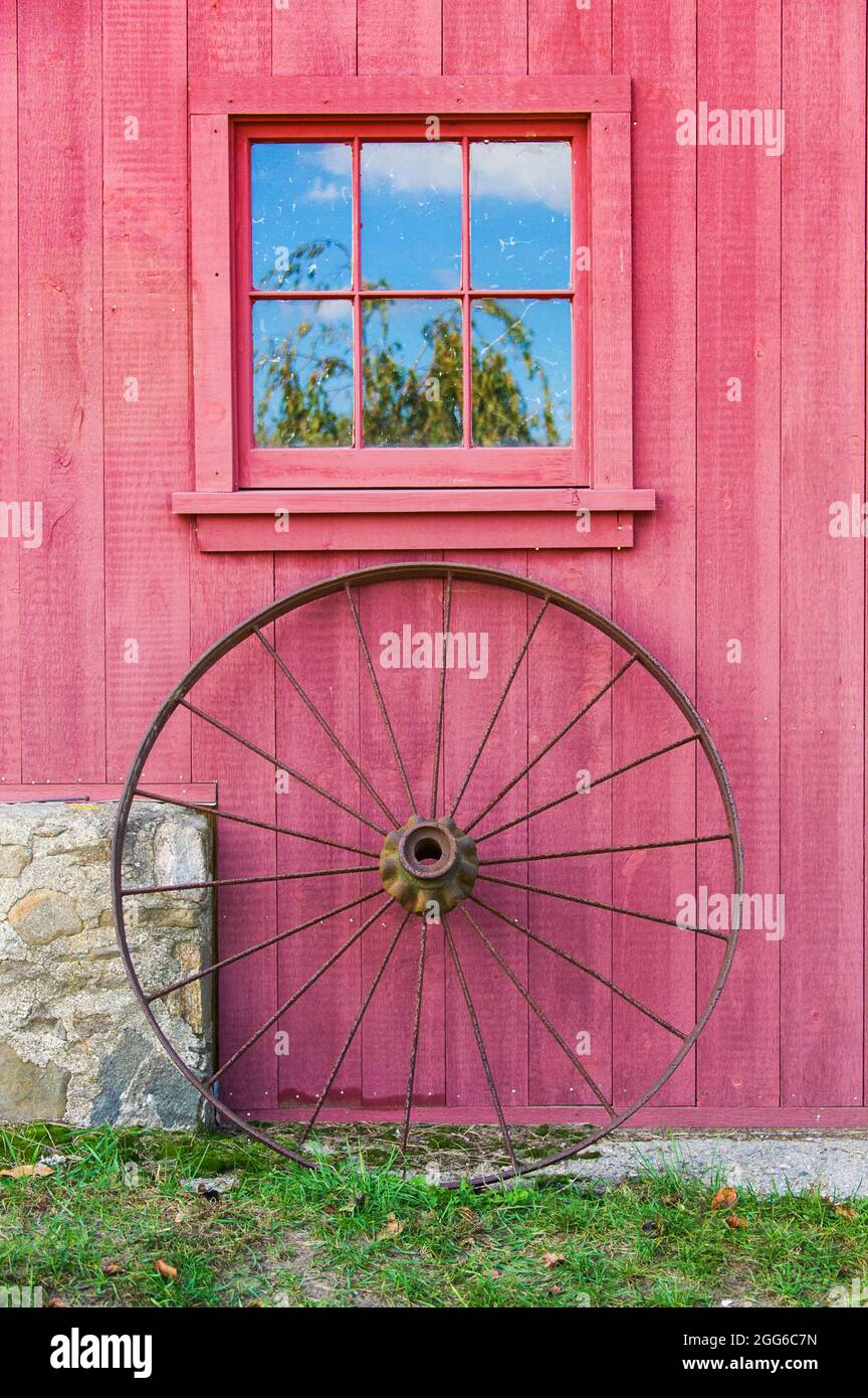 Red barn wall window with antique iron wagon wheel Stock Photo - Alamy
