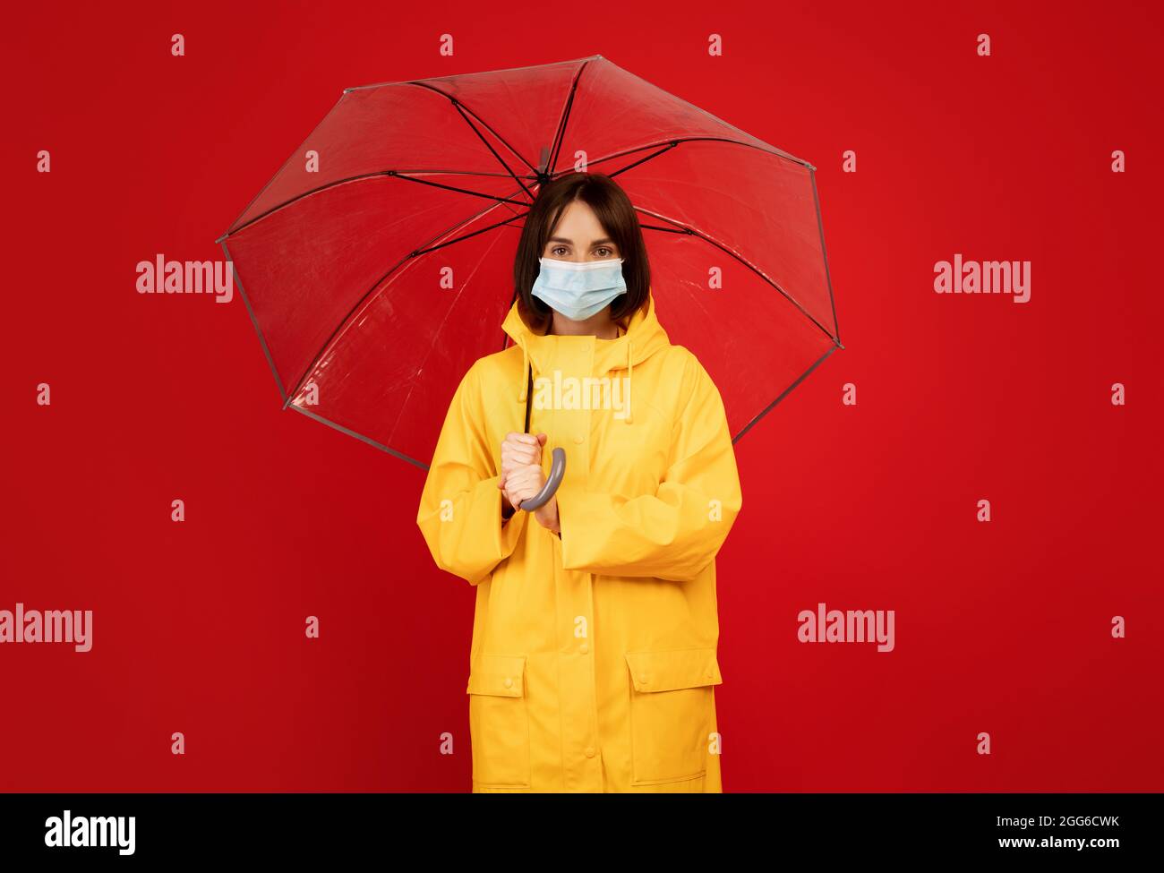 Protection concept. Portrait of young lady wearing raincoat and face ...